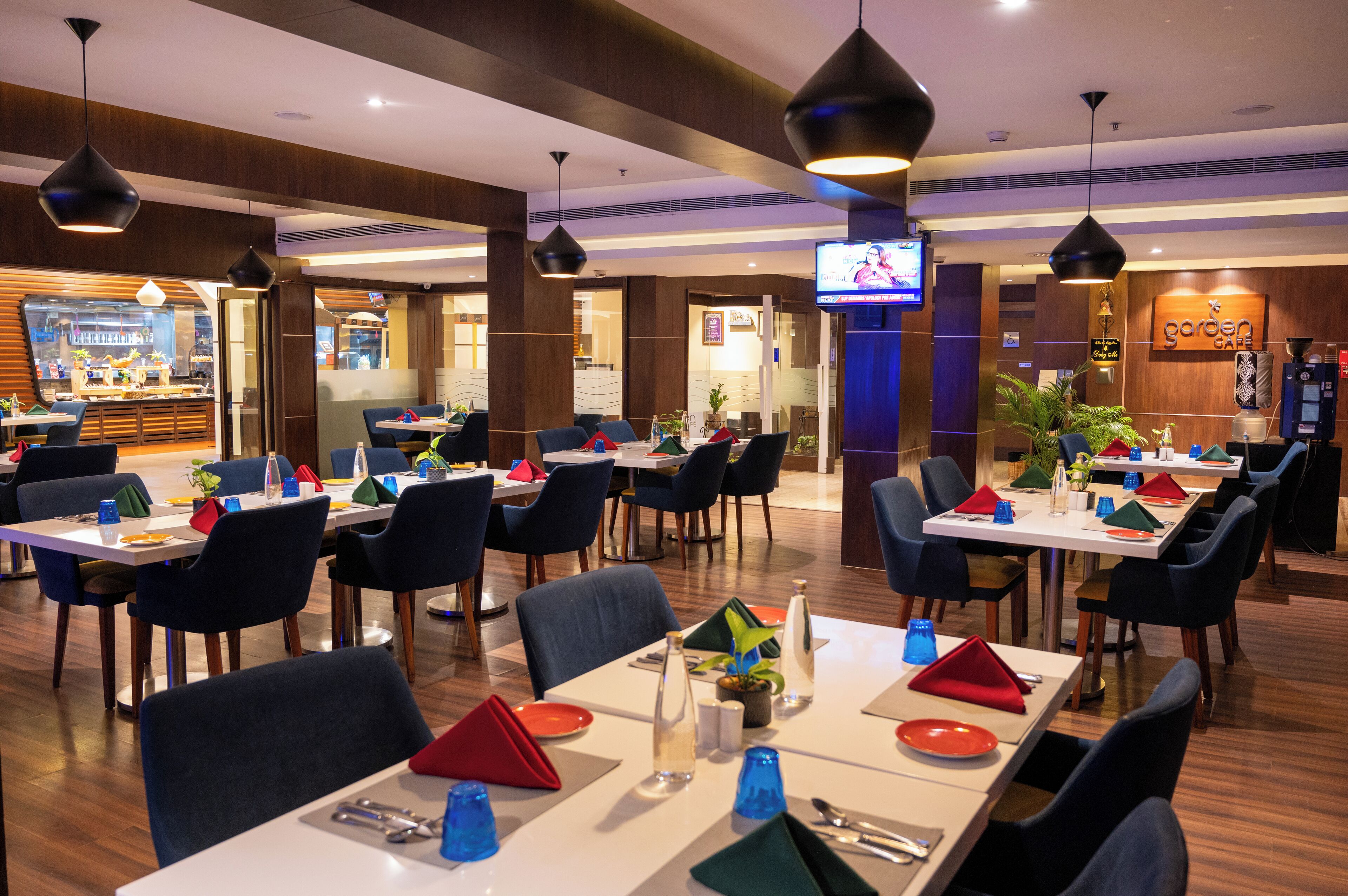 Um restaurante com várias mesas, cadeiras e um balcão de bar.