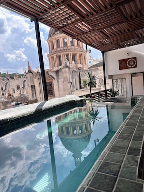 Piscina com vista para um edifício histórico.