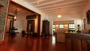 Um quarto espaçoso com piso de madeira lustrosa, um armário grande de madeira e um lustre.