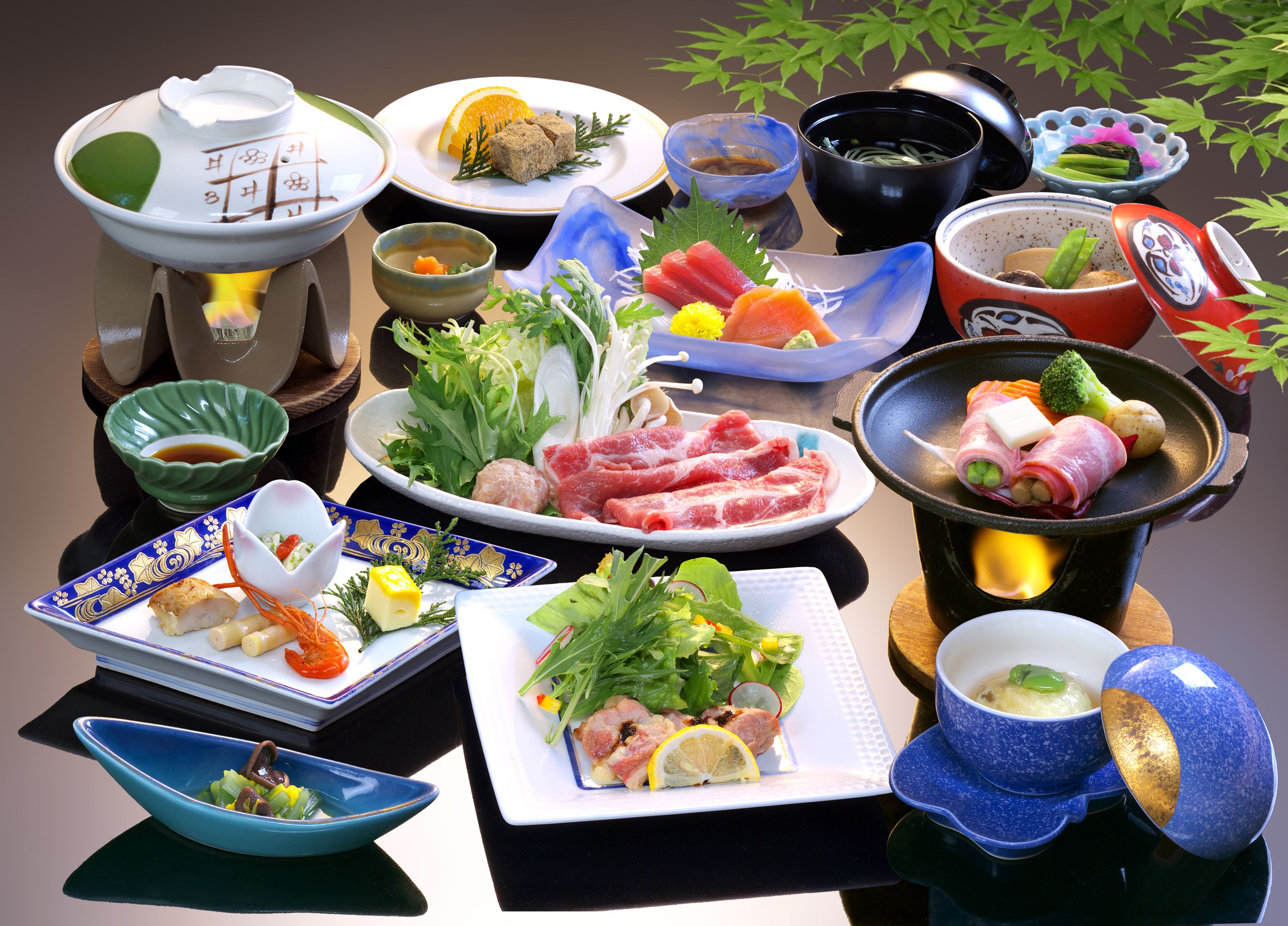 Diversos pratos japoneses, incluindo sashimi, legumes e uma preparação para fondue.