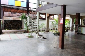 Um espaço amplo e coberto com escada, áreas de estar e plantas.