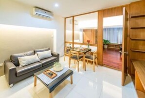Uma sala de estar moderna com sofá, mesa de centro e área de jantar.