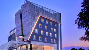 Um edifício moderno com design angular único, com vários andares e fachada destacada com padrão semelhante a uma grade.