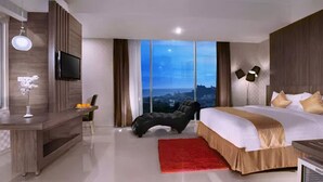 Quarto de hotel moderno com uma cama grande, uma escrivaninha, uma TV e vista para a paisagem urbana.