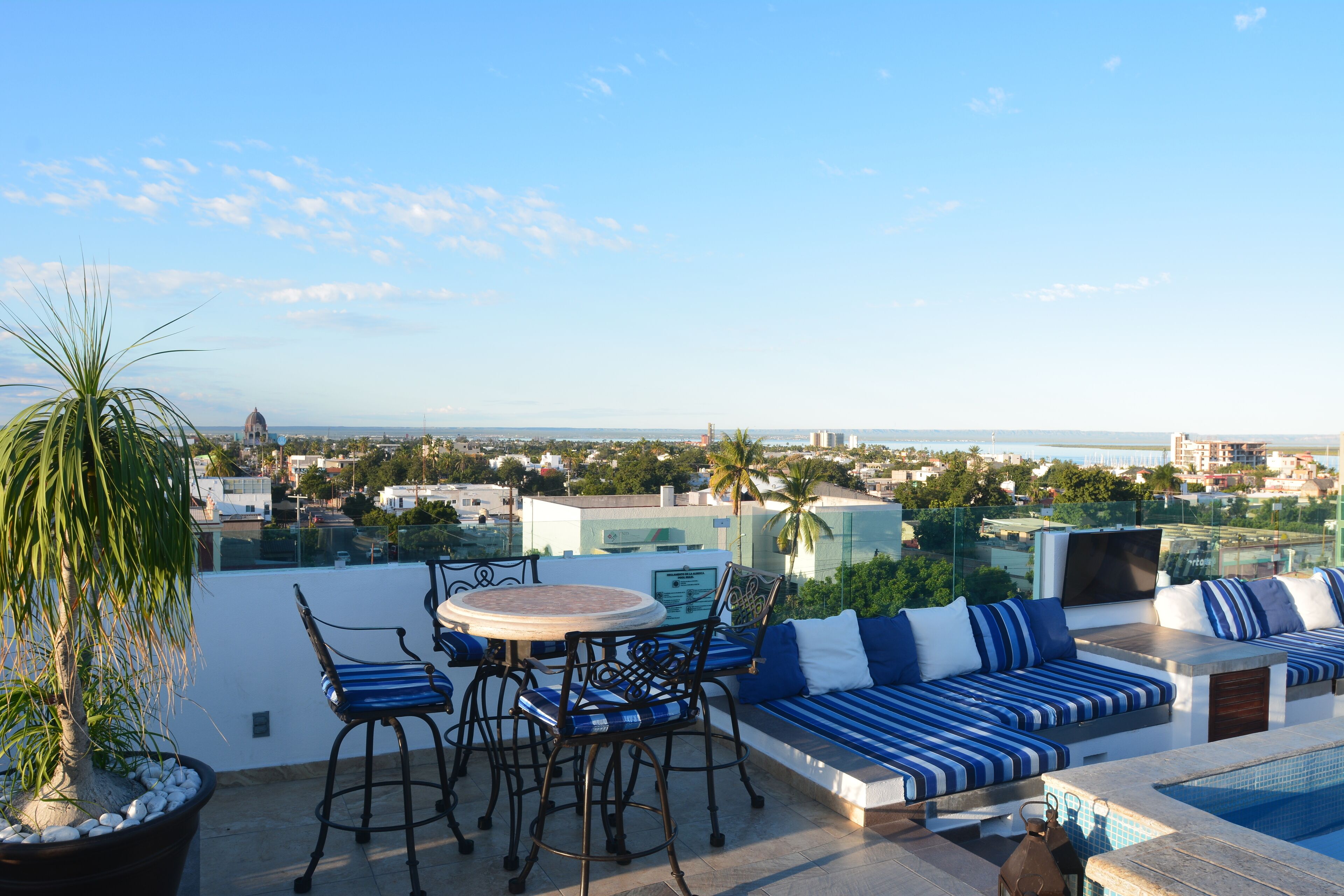 Terraço no telhado com piscina, área de estar e mesa de jantar.