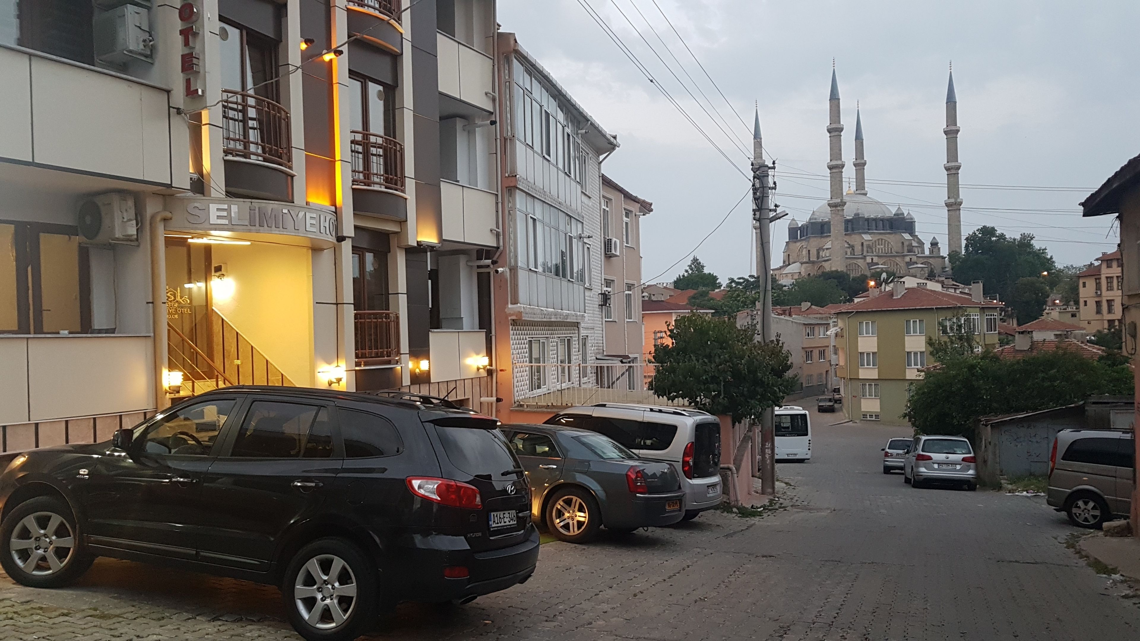 Rua com carros estacionados e um edifício com uma placa que diz "SELMIYEHOTEL".