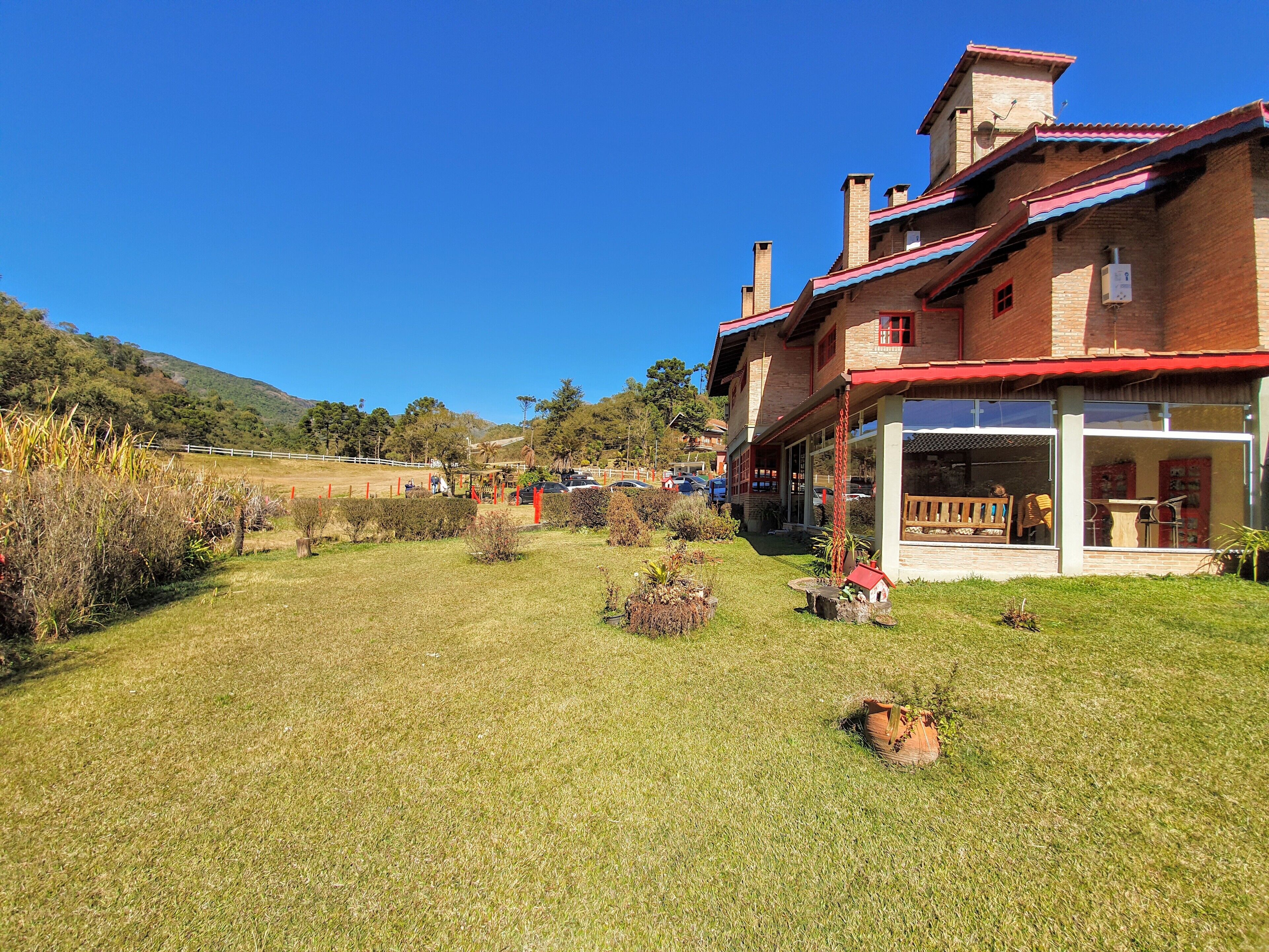 Uma casa de dois andares com telhado vermelho e varanda.