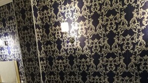 Cama bem arrumada com duas almofadas com a etiqueta "VERSAL" e uma toalha dobrada sobre a cama.
