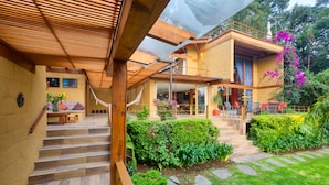 Uma casa moderna com uma escadaria de madeira que dá para uma varanda coberta.