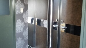 Um elevador moderno com paredes metálicas e superfície espelhada.