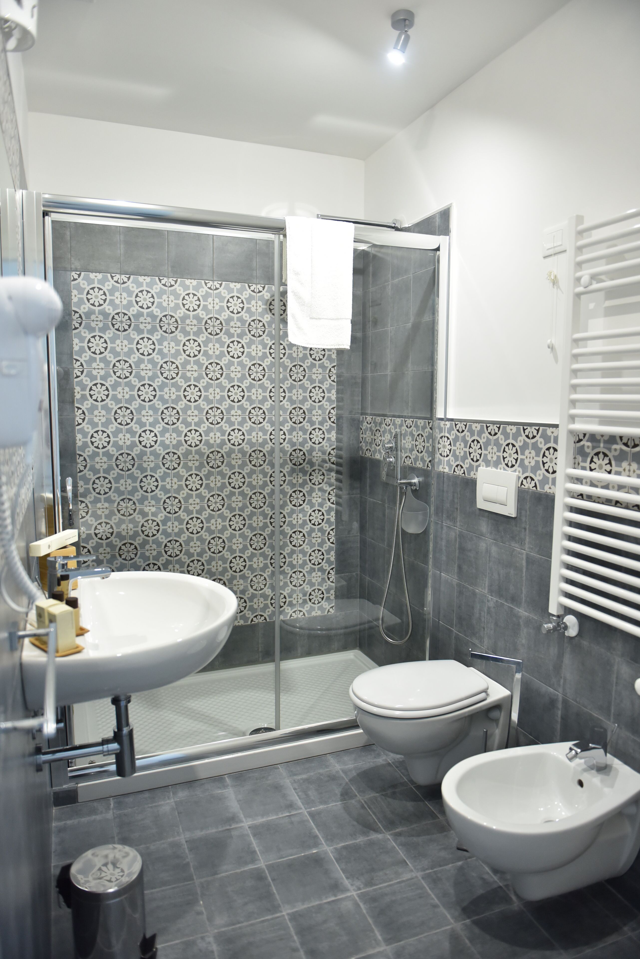 Uma casa de banho moderna com chuveiro, sanita, bidé e lavatório.
