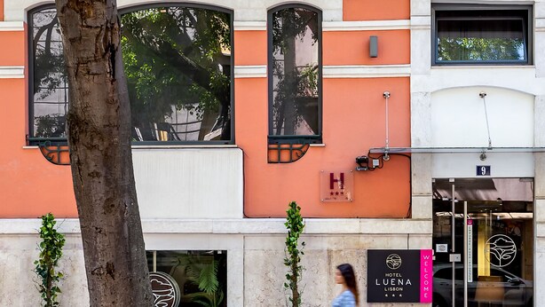 Entrada de hotel com uma placa indicando "Hotel Luena Welcome".