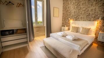 Quarto com cama, mesa de cabeceira, armário e vista para o exterior.