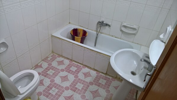 Um banheiro com vaso sanitário, pia e banheira.