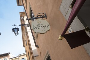 Um edifício com uma placa que diz 'Albergo Mazzanti Verona'.