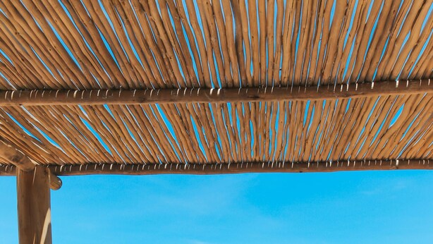 Um espaço de relaxamento à beira-mar, com uma mesa posta para dois, com vista para o oceano.