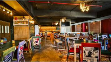Um restaurante acolhedor com mobiliário de madeira, espaço de bar e chão estampado.