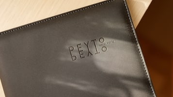 Uma pasta de couro preta com texto em relevo: "REXTO HOTEL PEXTO".