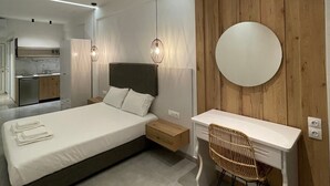 Quarto moderno com cama, mesa de cabeceira, escrivaninha, cadeira e painel de parede em madeira.