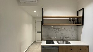 Uma cozinha moderna com máquina de lavar louça embutida, pia e painel de fundo em mármore.