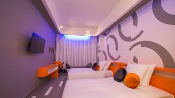 Quarto de hotel moderno com duas camas, televisão de tela plana, escrivaninha e uma janela grande com cortinas.