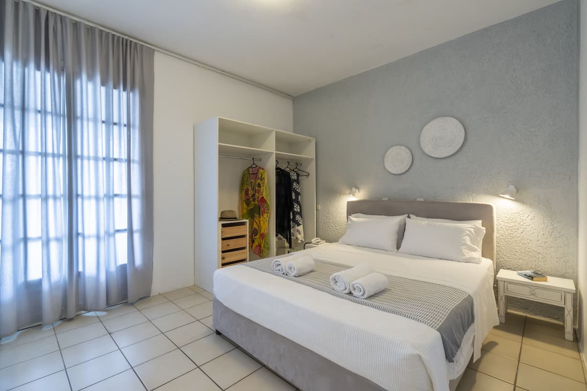 Quarto bem arrumado com cama grande, closet espaçoso e mesa de cabeceira.