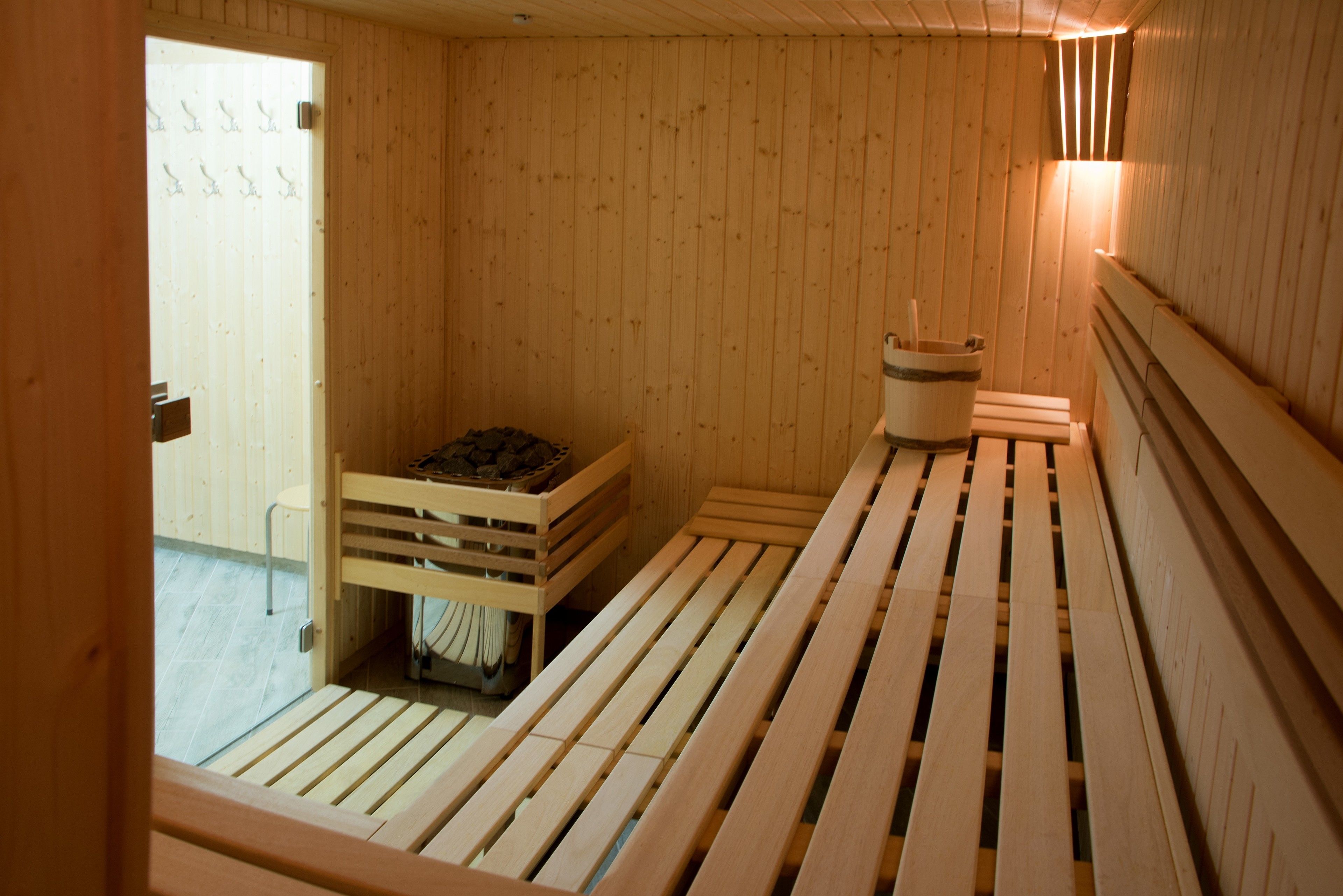 Uma sala de sauna com bancos de madeira e um banco com assento aquecido.