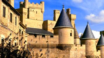 Um castelo de pedra histórico com várias torres e uma torre central imponente.