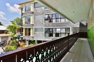 Um edifício de vários andares com varandas e um deck de madeira.