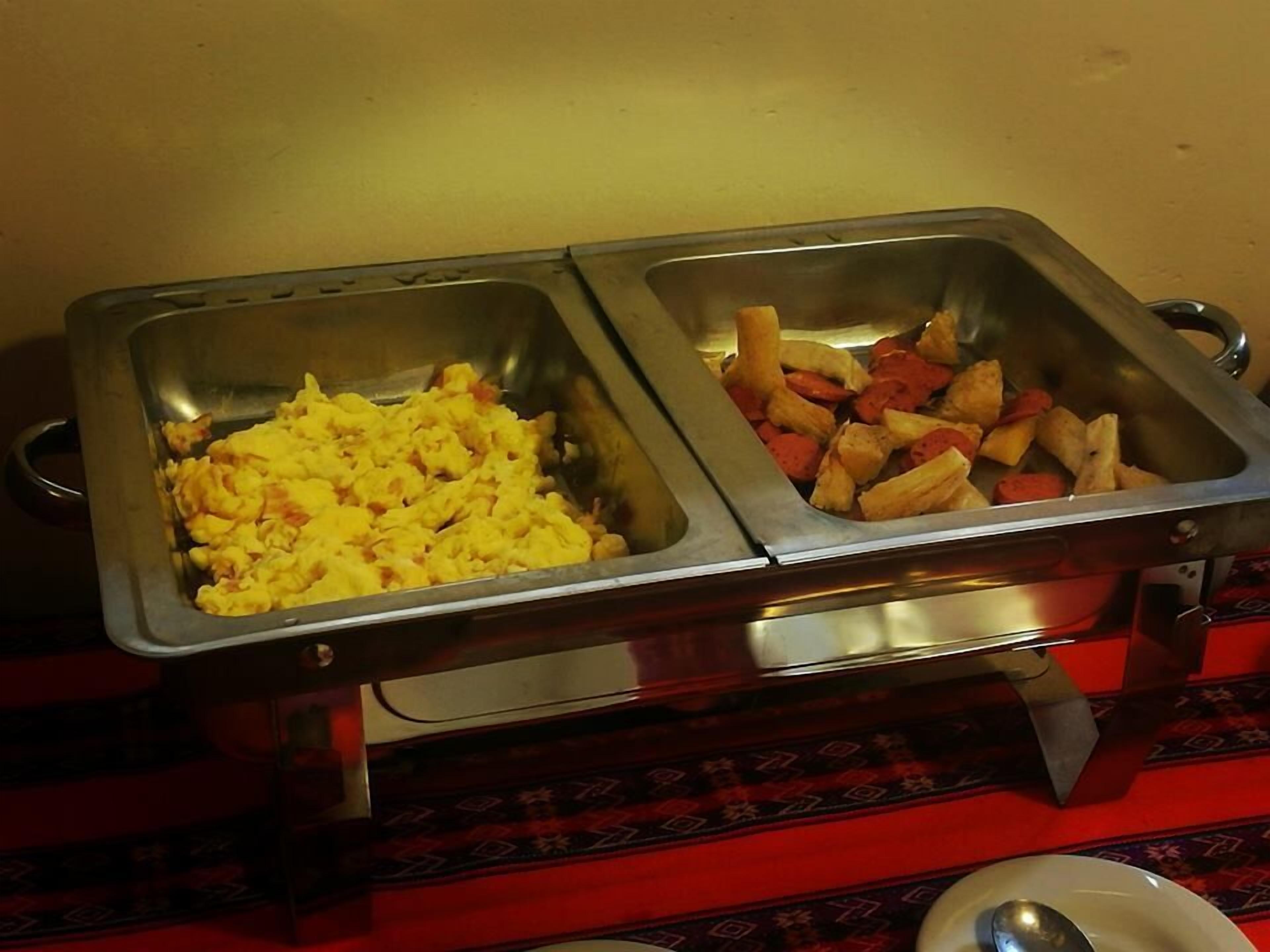 Buffet com ovos mexidos e batatas assadas.