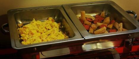 Buffet com ovos mexidos e batatas assadas.