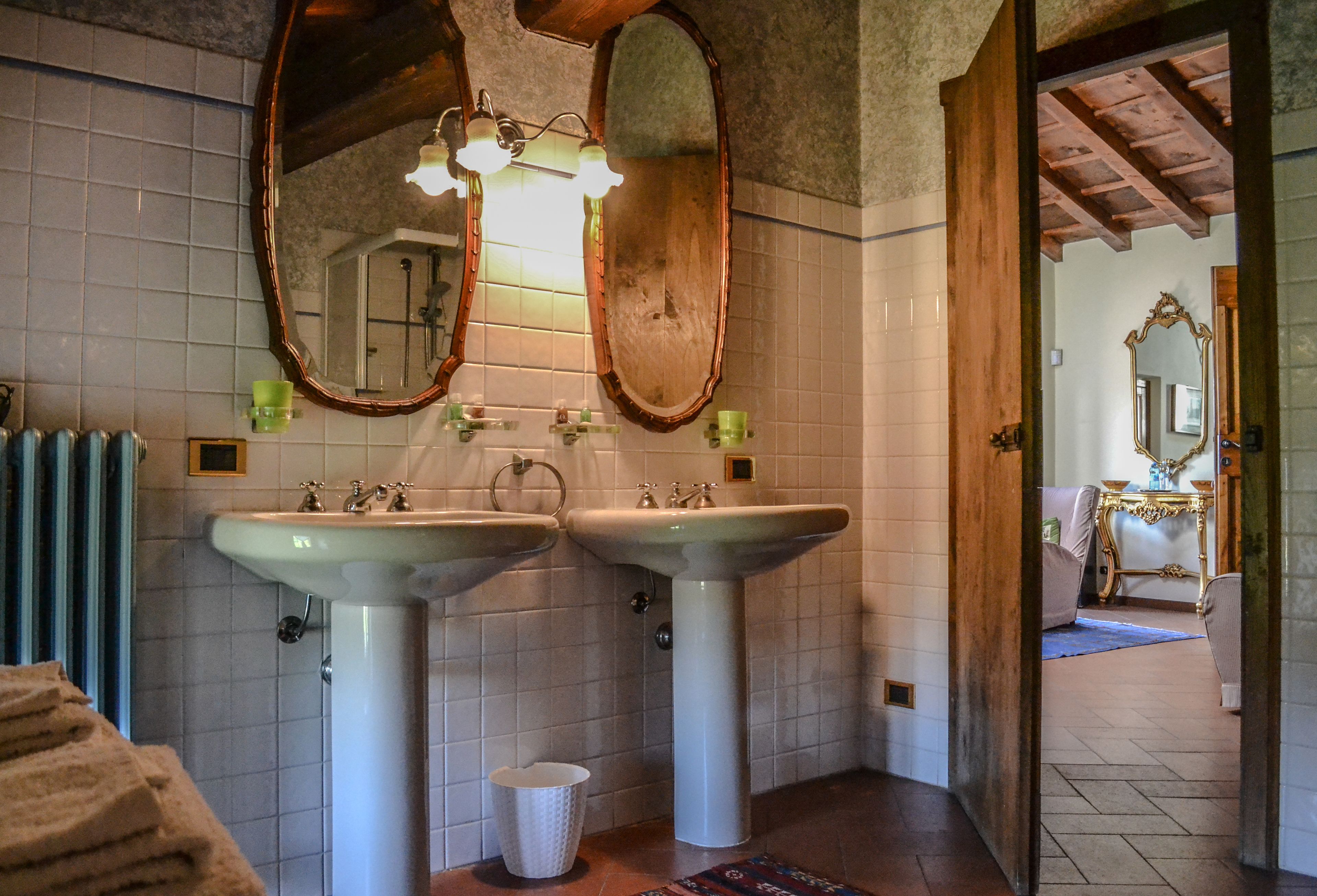 Casa de banho com duas pias, um espelho e um porta-toalhas.