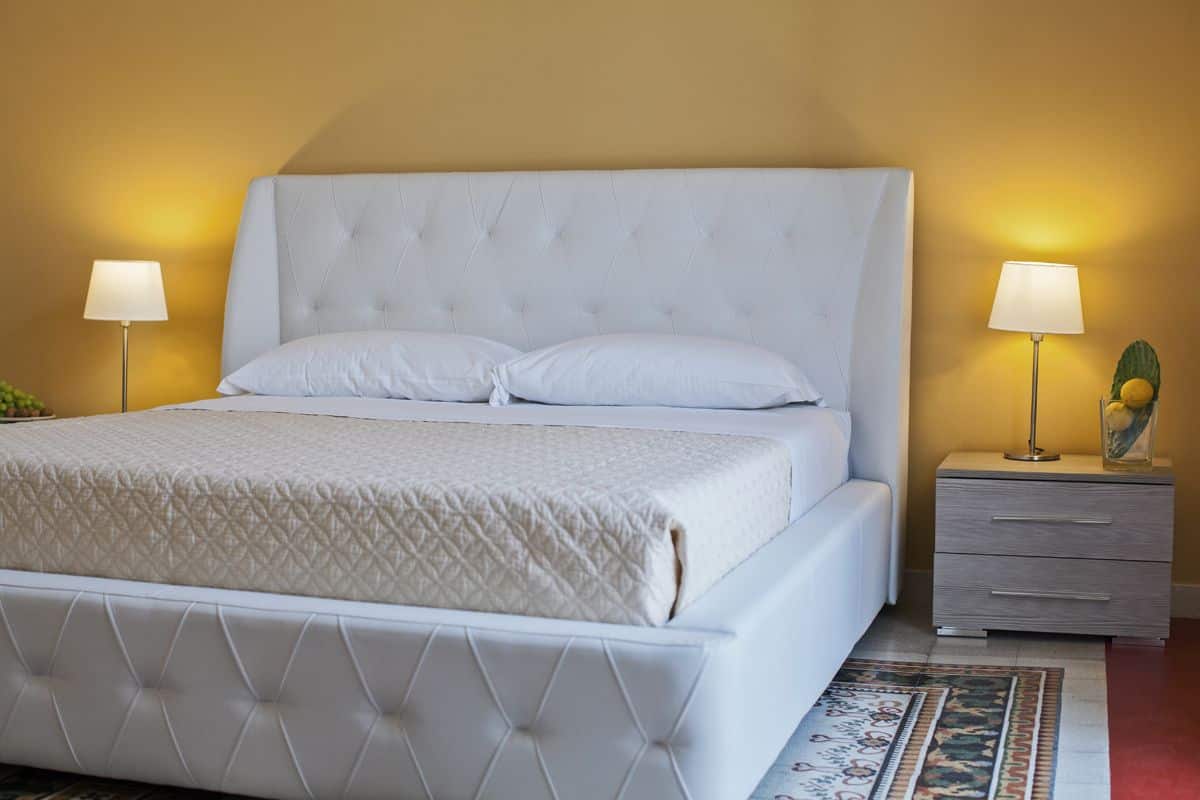 Quarto com uma cama grande, duas mesas de cabeceira e um criado-mudo.