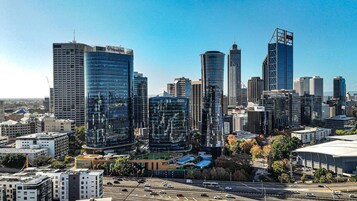 Silhueta urbana com edifícios modernos altos, uma autoestrada e um estádio.
