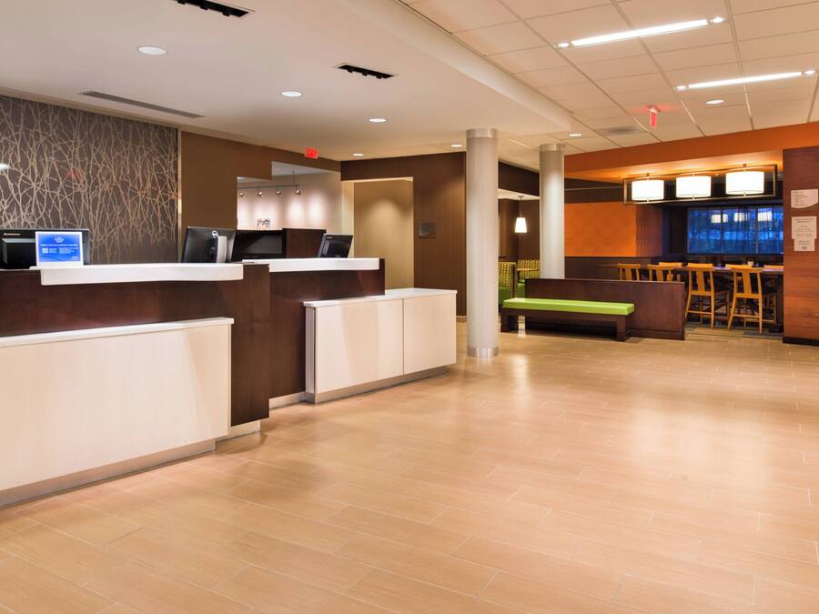 Uma área de recepção de hotel com balcão, sala de estar e bar.