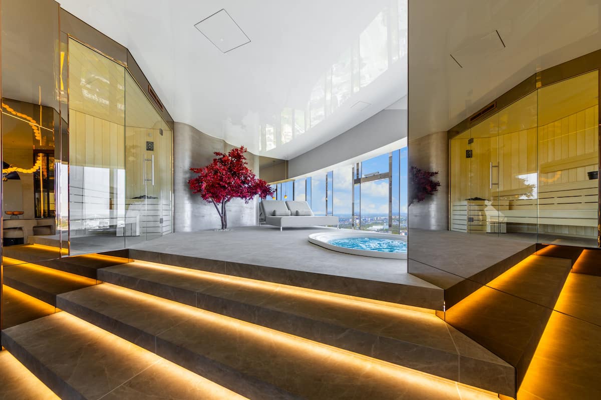 Um interior moderno com parede de vidro, piscina e escadaria.