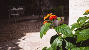 Uma área de pátio com móveis de exterior e um vaso de planta.