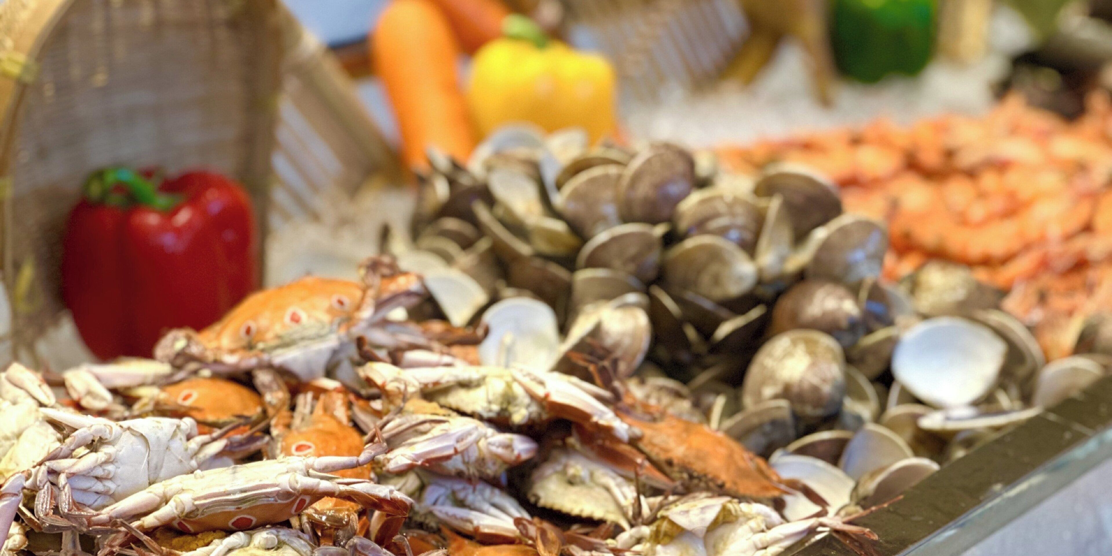 Exposição de frutos do mar com diversos tipos de mariscos e crustáceos.