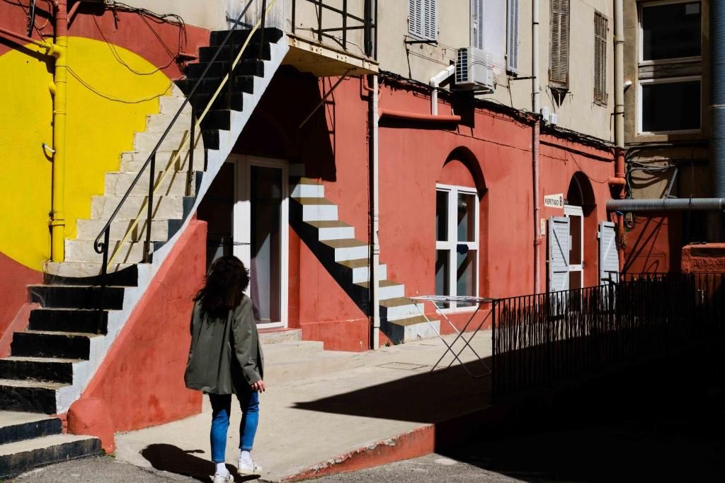 Um edifício com fachada vermelha, escadaria e parede amarela.