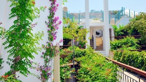 Um edifício branco com uma escadaria que leva a uma área coberta.