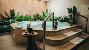 Uma área de spa com hidromassagem, escadas e uma mesa com uma bandeja de objetos.