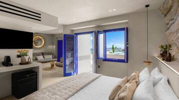 Quarto moderno com uma cama grande, uma escrivaninha e vista para o mar através de uma janela.