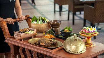 Uma mesa de madeira com diversos pratos, incluindo carne grelhada e uma decoração floral.