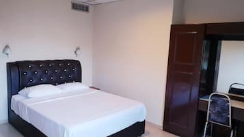 Quarto com uma cama grande, uma escrivaninha e um guarda-roupa.
