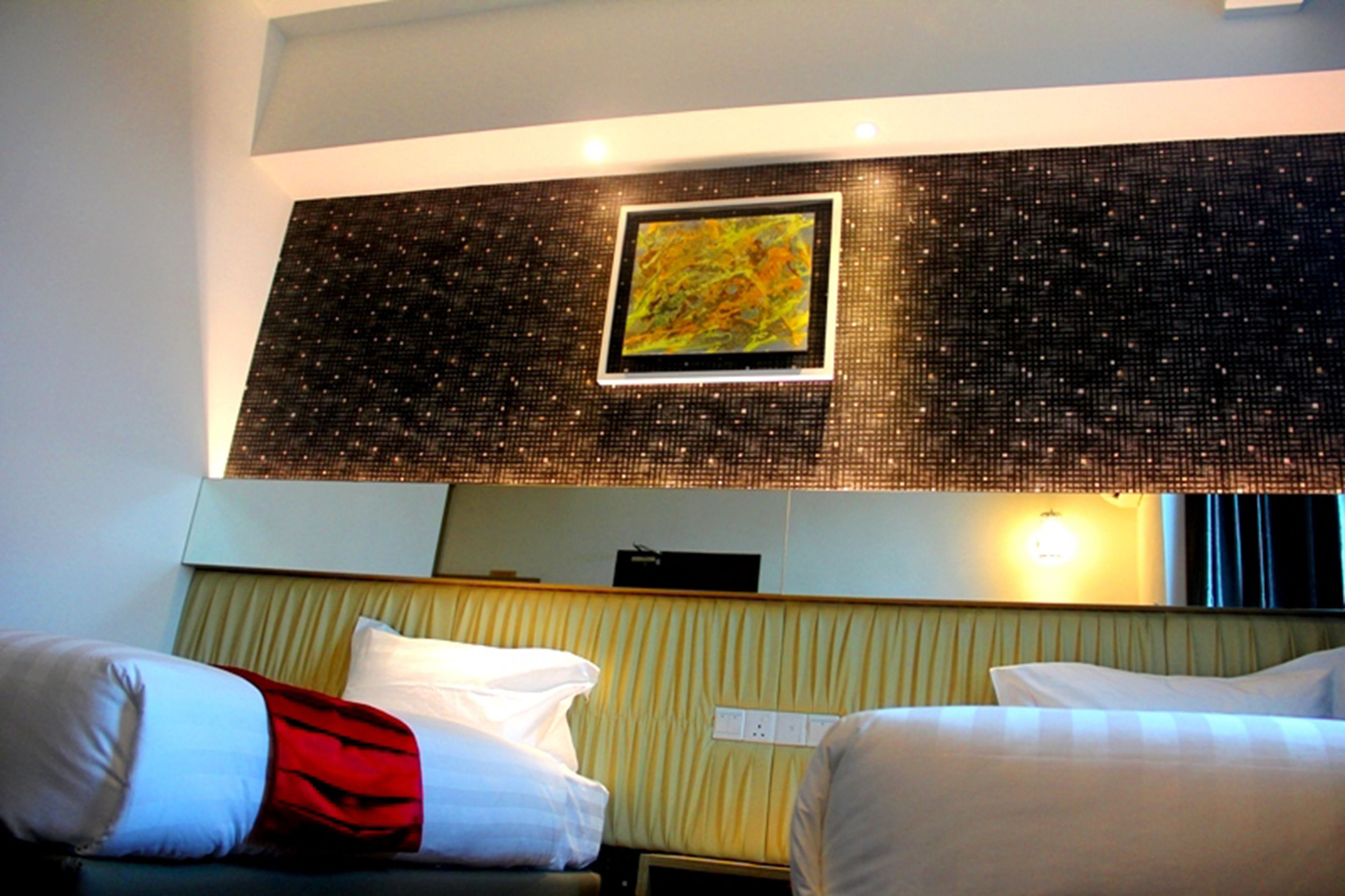 Quarto de hotel com duas camas, um espelho grande e uma obra de arte pendurada na parede.