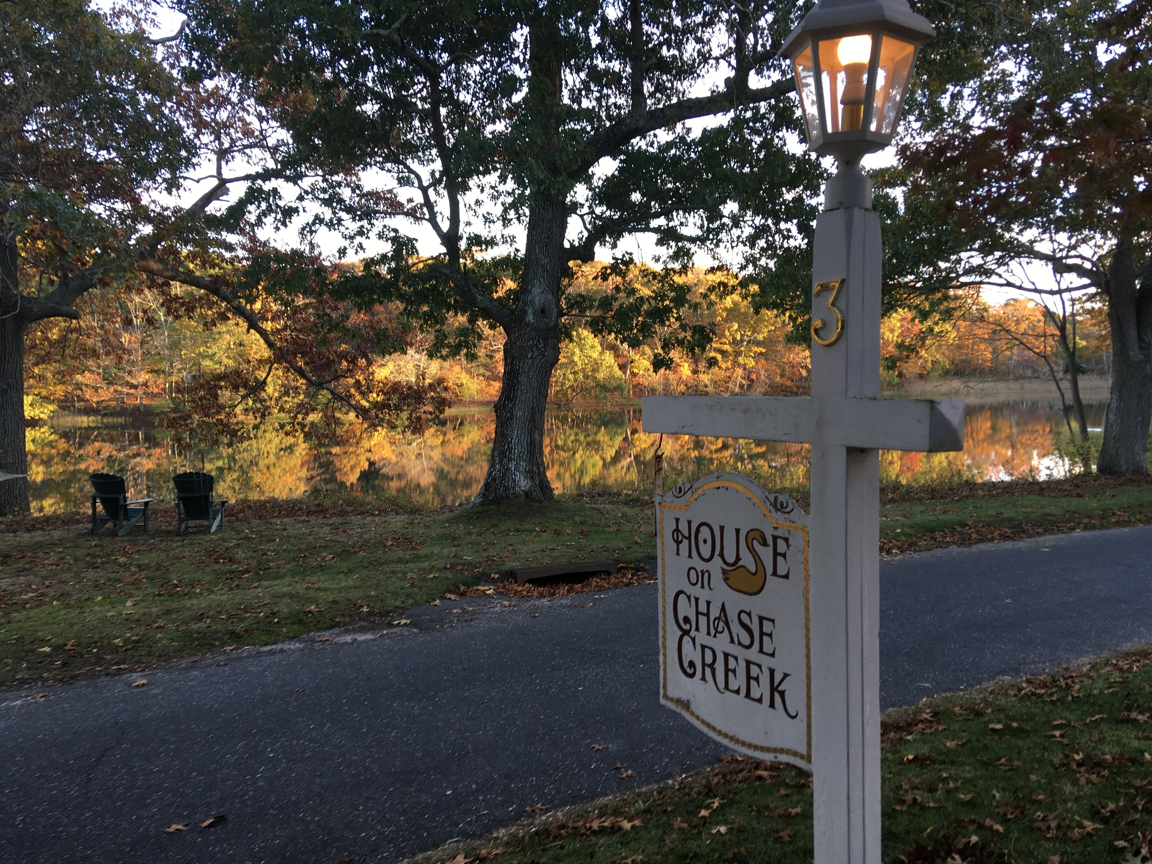 Placa de 'House on Chase Creek' com um poste de luz próximo.