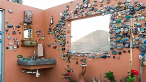Um banheiro com pia, espelho e diversos objetos decorativos, incluindo pedras e um vaso.