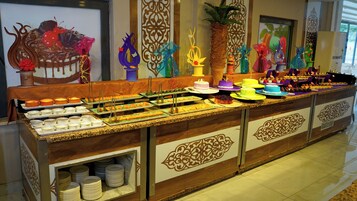 Buffet com diversos pratos e sobremesas.
