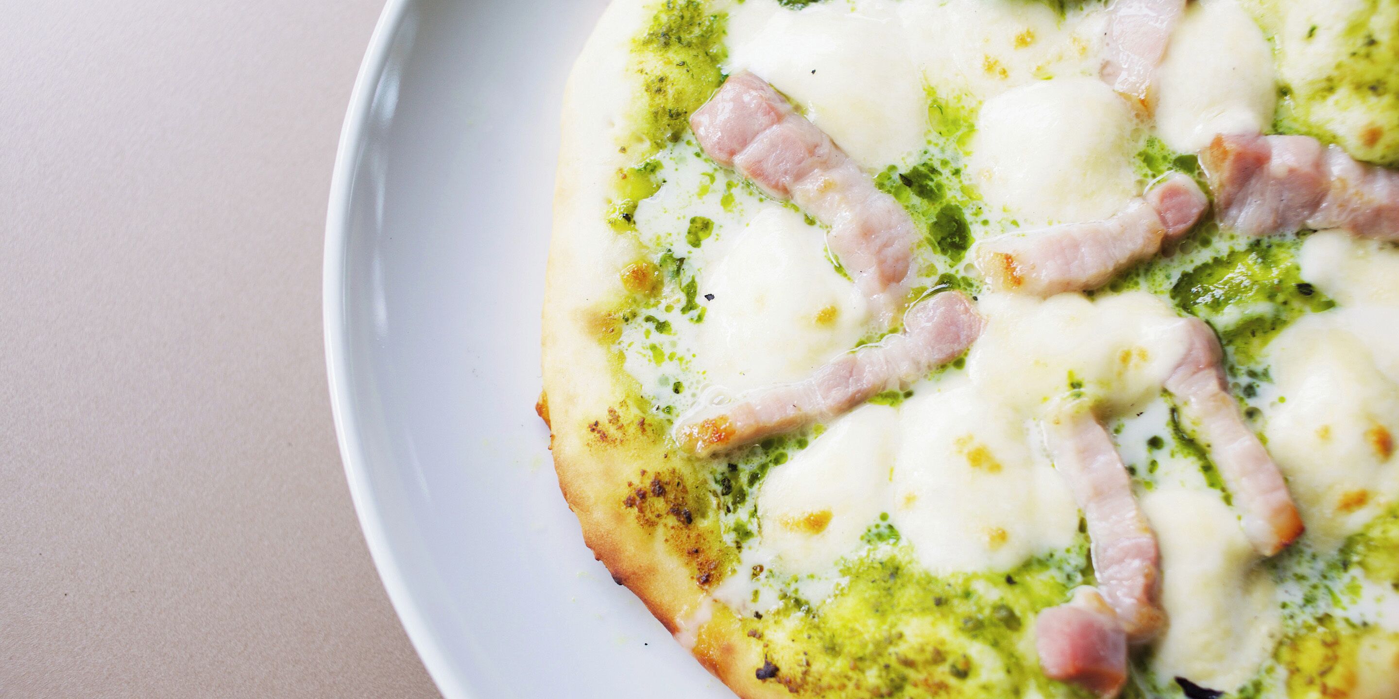 Um prato com queijo e pesto verde.
