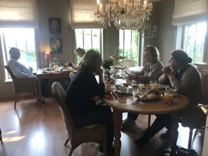 Uma área de refeições com uma mesa redonda, cadeiras e um lustre.